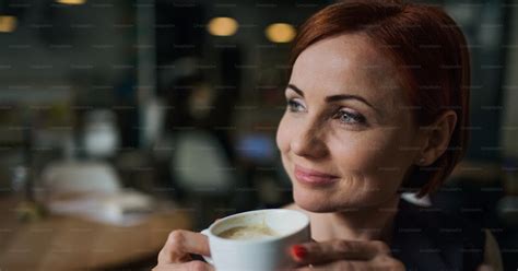 카페에 앉아 커피 한 잔을 들고 있는 매력적인 여성의 초상화 사진 Unsplash의 커피를 마신다 이미지