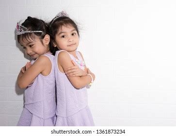 Female Asian Identical Twins Sitting On Stock Photo Edit Now