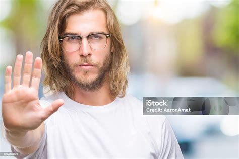 중지 하 고 격리 된 배경 위에 긴 머리 착용 안경 잘생긴 젊은이 손의 종 려를 가진 노래 얼굴에 부정적이 고 심각한 제스처와