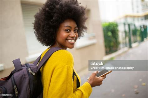 도시 거리에서 걷는 가방과 휴대 전화로 미소 짓는 아프리카 계 미국인 여성의 뒤에 걷기에 대한 스톡 사진 및 기타 이미지 걷기 등 여자 Istock