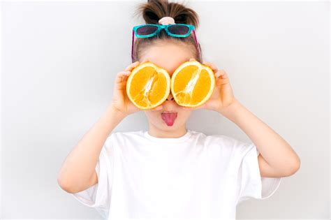 재미 있고 긍정적 인 소녀는 흰색 빈 티셔츠를 입고 있습니다 오렌지를 가진 세련 된 귀여운 소녀 디자인을 위한 템플리트 로고를 위한 사본 공간 원본 정면 View 모형 여름