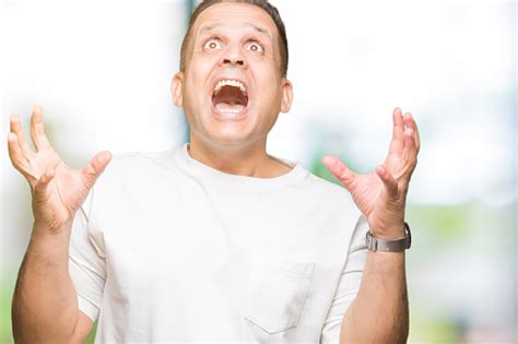 중세 아랍 남자 Wearig 격리 된 배경 축 화 및 무기와 성공을 위해 미친 동안 티셔츠 제기 하 고 흥분 비명 눈을 폐쇄 우승자 개념 T 셔츠에 대한 스톡 사진 및 기타