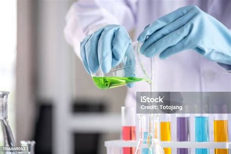 실험실 배경 과학 또는 의학 연구 및 개발 개념에 실험실 유리를 가진 플라스 크에 있는 샘플링 기름 또는 화학 액체를 들고 있는