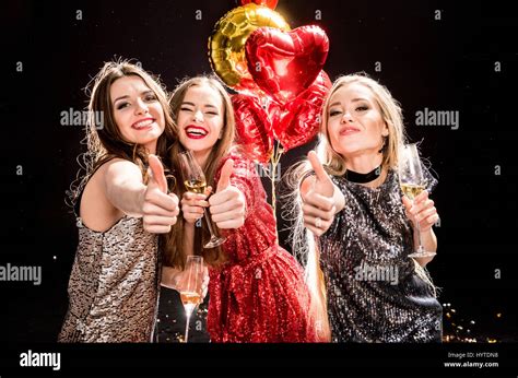 Three Gorgeous Women Showing Thumbs Up And Holding Glasses Of Champagne