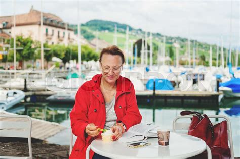 Year Old Woman Resting Outdoors Reading Book In Cafe By Lake