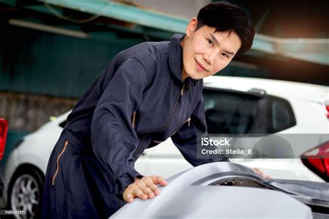 자동차 부품 엔진 차량과 함께 일하는 제복을 입은 아시아의 잘생긴 정비사 남자 차고 자동차 수리 서비스 상점에서 고객 자동차 자동차의 유지 보수 엔진 시스템을 검사하는