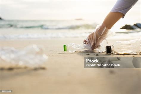 가까이 여자 손 해변에서 플라스틱 병을 데리러 여성 자원 봉사자는 해변의 쓰레기를 청소하여 바다를 아름답게 만듭니다 세계 환경의 날 개념 개념에 대한 스톡 사진 및 기타