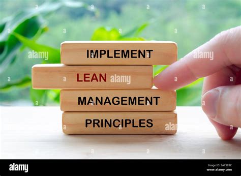 Implement Lean Management Principles Text On Wooden Blocks Representing Continuous Improvement