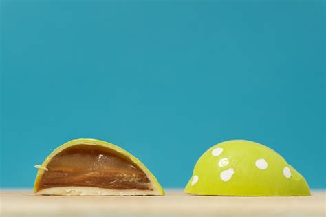 수제 녹색 점선 초콜릿 봉봉 슬라이스를 닫습니다 손으로 그린 사탕의 구색 사탕은 반으로 자른다 복사 공간이 있는 모형 파란색 배경에 쇼콜라티에 부활절 제품의 매크로 샷