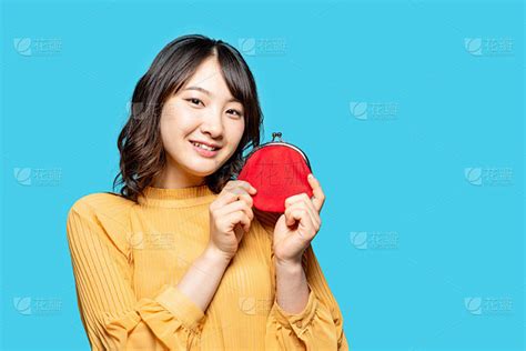 年轻的亚洲女孩拿着一个钱包。