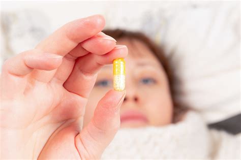 스카프에 싸여 어린 예쁜 소녀는 집에서 아프다 침대에 누워 그녀의 손에 약과 캡슐을 보유 30 34세에 대한 스톡 사진 및 기타 이미지 30 34세 가정 생활 가정의