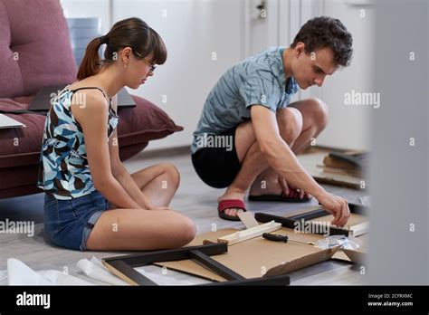 Young Couple Assembling Furniture In Their New Home New Life Concept