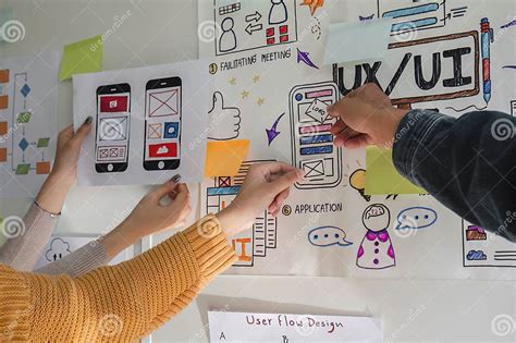 Image Of A Team Of Developers Brainstorming Ui And Ux Design Ideas For A Mobile App On A Paper