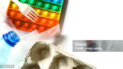 재활용 고무 장난감 팝 그것 플라스틱 폐기물에 의한 환경 오염의 개념 병 포크 패키지의 쓰레기와 간단한 보조개의 상단 보기 흰색