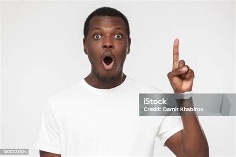 생각이 있어 그의 머리 위에 뭔가 보여주는 검지 손가락으로 제스처를 만드는 잘생긴 Afrcian 미국 사람 손가락을 유지 이상