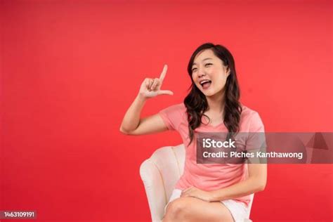 행복 한 아름 다운 아시아 여자는 미소 짓고 빨간 배경에 캐릭터 L을 만듭니다 새해 크리스마스 및 발렌타인 데이 개념 손에 대한