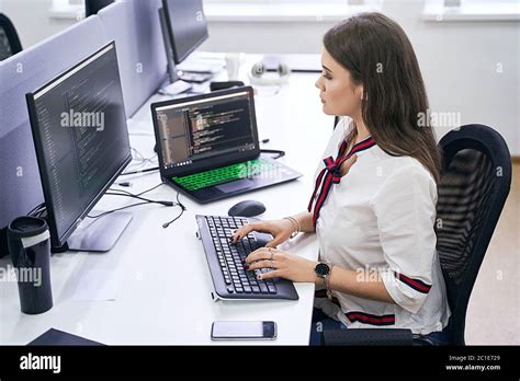 Beautiful Female Junior Software Developer Working On Computer In IT Office Sitting At Desk And