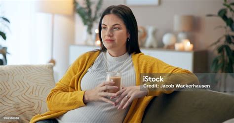 커피 임산부와 함께 느긋하게 생각하고 집의 소파와 거실에서 출산 휴가 건강을 위한 공간 휴식 따뜻한 음료 유리잔이 있는 미래의 엄마 아파트 임신 또는 휴식을 위한 편안함