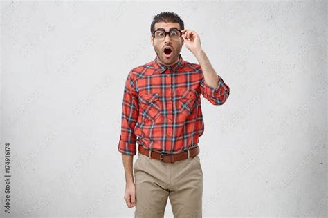 Horizontal Shot Of Funny Emotional Male Nerd In Ridiculous Clothes Looking At Camera In Shock