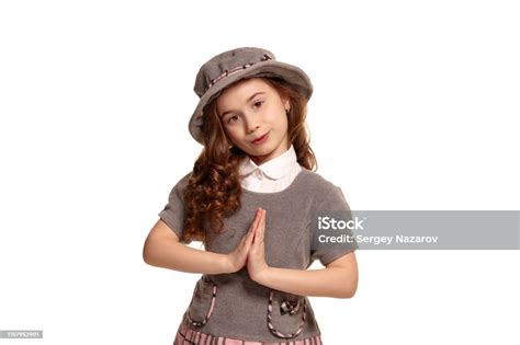 흰색 배경에 고립 된 포즈를 취한 길고 곱슬 한 머리카락을 가진 사랑스러운 어린 아이의 스튜디오 샷 갈색 머리에 대한 스톡 사진