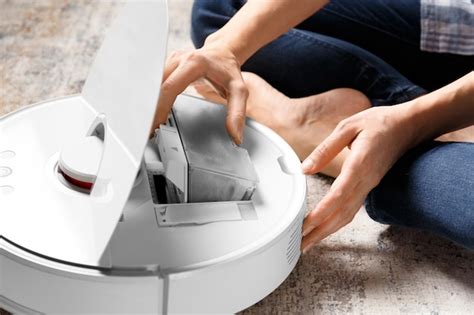 Premium Photo The Girl Takes Dust Container Out Of The Vacuum Cleaner Robot To Clean It