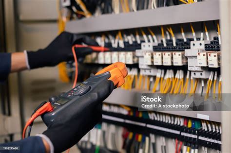 전기 엔지니어 작업 테스터 는 전기 캐비닛 제어에서 전력 전기 라인의 전압과 전류를 측정하고 릴레이 보호 시스템에 전선 베이