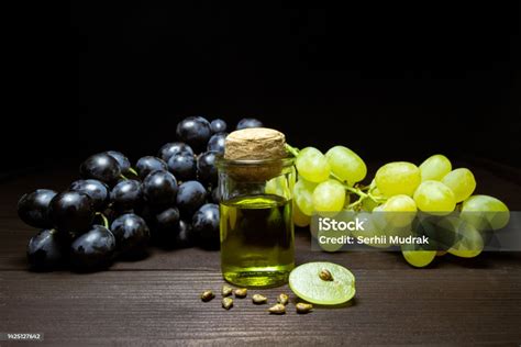 천연 포도 씨 기름 한 병 어두운 나무 테이블에 파란색과 흰색 포도가 잔뜩 있습니다 유기농 화장품 건강관리와 의술에 대한 스톡 사진 및 기타 이미지 Istock