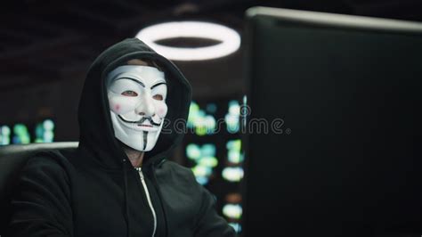 Masked Hacker Typing Keyboard Breaking Cybersecurity At Dark Datacenter