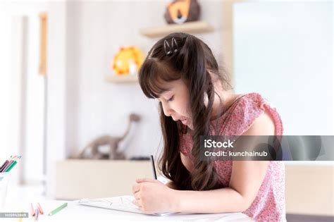 행복한 미소 짓는 젊은 아시아 학생 소녀 컬러 연필로 학습을위한 거실에서 캠퍼스 또는 학교 후에 숙제를하십시오 6 7 살에 대한 스톡 사진 및 기타 이미지 Istock