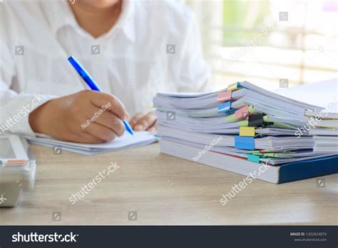 Teacher Is Checking Student Homework Assignment And Report On Desk In