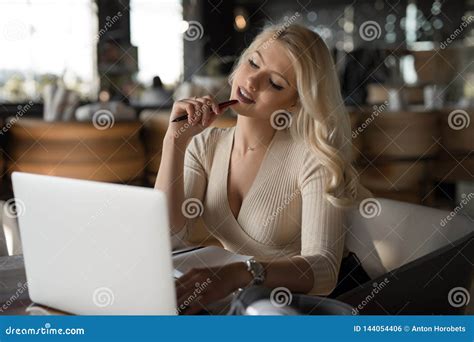 Blonde Business Woman Examining Contract While Sitting At The Glass