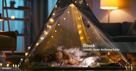 아이 요새 밤에는 가족 집에서 담요를 덮고 잠을 자고 낮잠을 자고 휴식을 취합니다 조명 테디 어린 소녀 아이 천막 집 거실에서 저녁 아이에 대한 스톡 사진 및 기타 이미지