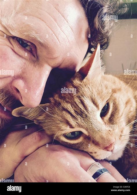 A Man And His Cat Cuddle Together Stock Photo Alamy