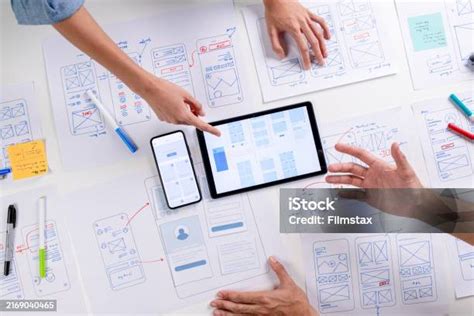Ux Ui Designers Discussing And Brainstorming On Wireframes For A Website And Mobile App
