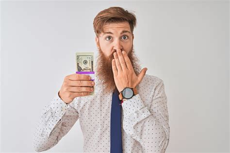 실수 두려움의 표현 침묵 비밀 개념에 무서워 수치로 충격을 손으로 고립 된 흰색 배경 커버 입 위에 서 달러를 들고 젊은 빨간 머리 아일랜드어 사업가 가리기에 대한 스톡