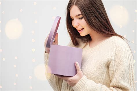 흰색 배경에 스웨터에 젊은 갈색 머리 여자입니다 크리스마스 선물 상자를 들고 기쁨 행복과 놀라움 갈색 머리에 대한 스톡 사진 및 기타 이미지 Istock