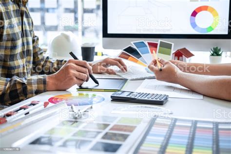 그래픽 태블릿과 현대 사무실에서 작업 색상 시계에 스케치 젊은 인테리어 그래픽 디자이너 작업 하우스 프로젝트의 팀 디자인 창조적 인 영감과 상상 개발에 대한 스톡 사진 및