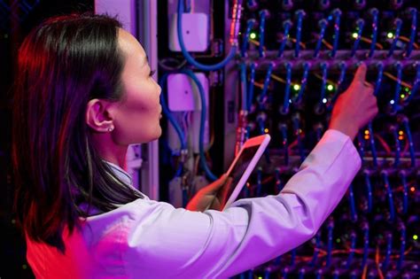 Premium Photo Rear View Of Busy Asian Female Network Engineer In Lab Coat Connecting Cables In