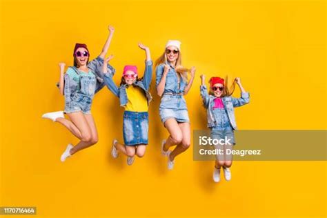 전체 길이 크기 사진 의 네 금발 의 갈색 머리 흥분 미친 쾌활한 빛나는 승리 좋은 기쁜 여자 친구 제기 주먹 까지 점프 올라 공기 고립 된 노란색 배경 가족에 대한 스톡