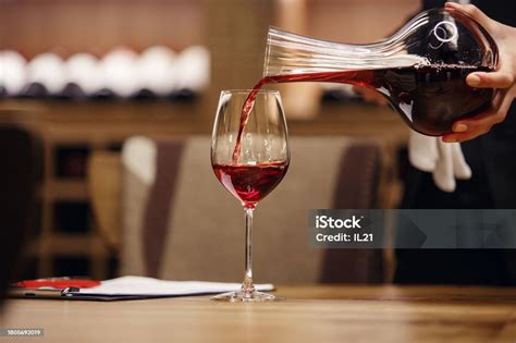 전문 여성 소믈리에가 디켄터에서 유리에 레드 와인을 붓고 이미지를 닫습니다 와인 가게의 지하실에 알코올 음료를 따르는 여성