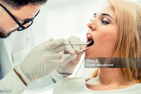 치과 진료소에서 치과 의사의 자에 앉아 행복 한 여자 환자의 이빨을 검사 하는 젊은 잘생긴 치과 의사 치과 치료 개념입니다 2명에 대한 스톡 사진 및 기타 이미지 Istock
