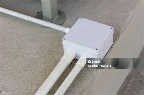 플라스틱 파이프와 전기 케이블사각형 바닥 상자 바닥에 흰색 전기 접합 상자와 전선 콘크리트 바닥에 전기 배선의 설치 0명에 대한