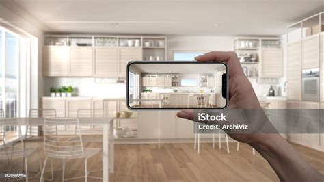 손을 잡고 스마트 폰 Ar 응용 프로그램 실제 가정에서 가구 및 인테리어 디자인 제품을 시뮬레이션 건축가 디자이너 개념 흐림 배경 현대적인 흰색과 나무 부엌 Brand