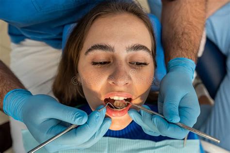 Dentist And Assistant In Masks And Uniforms Making Professional Teeth