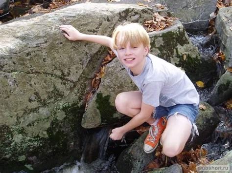 Красивый мальчик в рваных джинсовых шортах Шорты фото