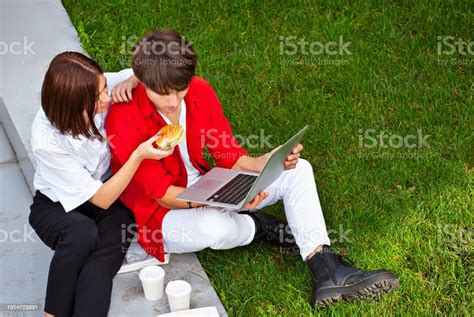 소년과 소녀는 함께 야외에서 점심을 먹는다 랩톱 화면을 보고 커플 패스트 푸드와 길거리 음식의 개념 종이 용기와 일회용 컵의 음식 18 19세에 대한 스톡 사진 및 기타