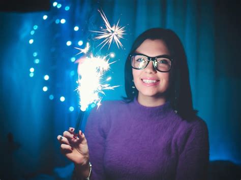 Premium Photo Smiling Young Woman With Illuminated Firework At Night Premium Photo Smiling Young Woman With Illuminated Firework At Night