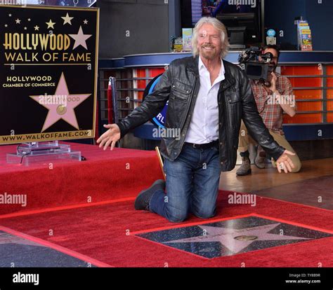 Sir Richard Branson Kneels Next To His Star During An Unveiling