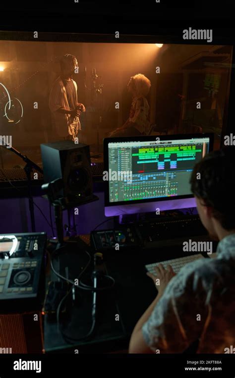 crop male audio engineer typing on keyboard while working on computer