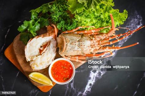 접시에 가시 랍스터 음식 신선한 랍스터 또는 바위 랍스터 허브와 향신료를 곁들인 해산물 레몬 고수풀 파슬리 양상추 샐러드 음식